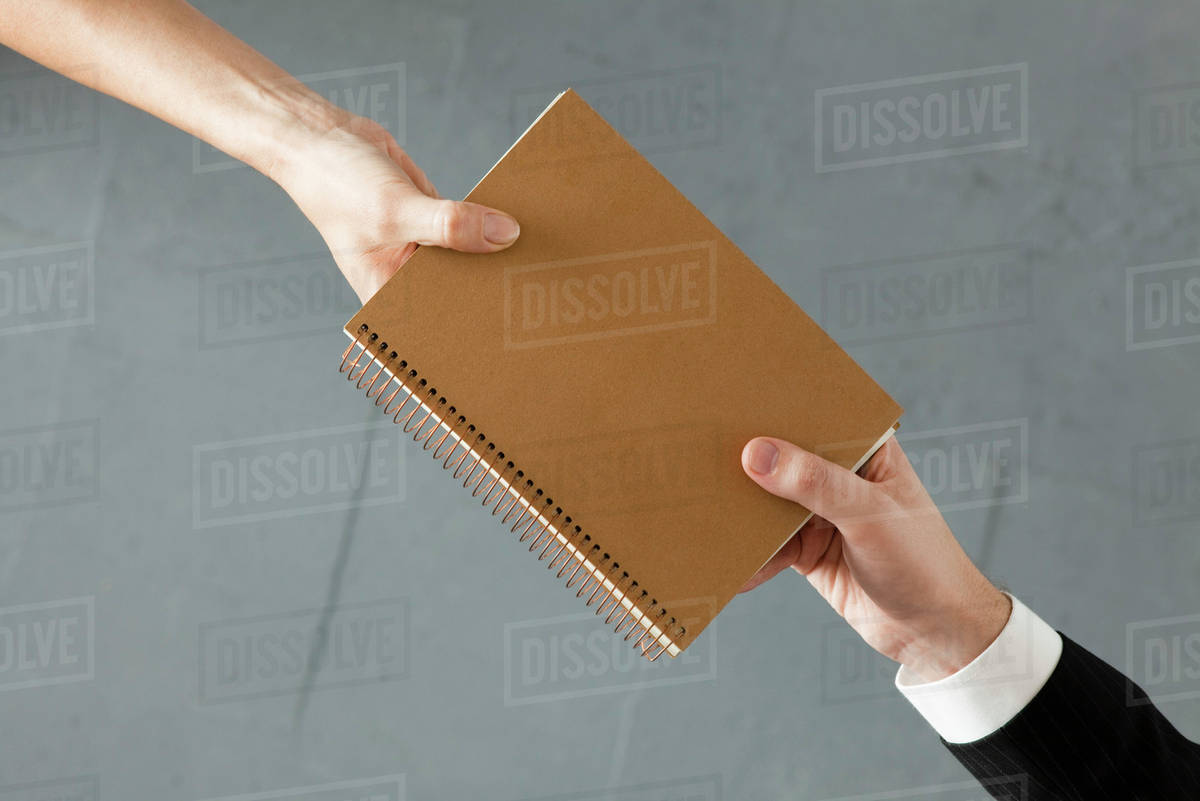 Handing colleague notebook - Stock Photo - Dissolve