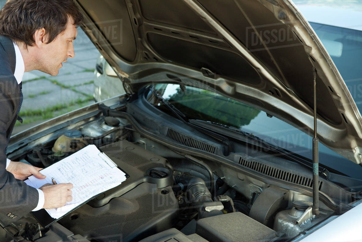 Inspecting car engine - Royalty-free Stock Photo | Dissolve