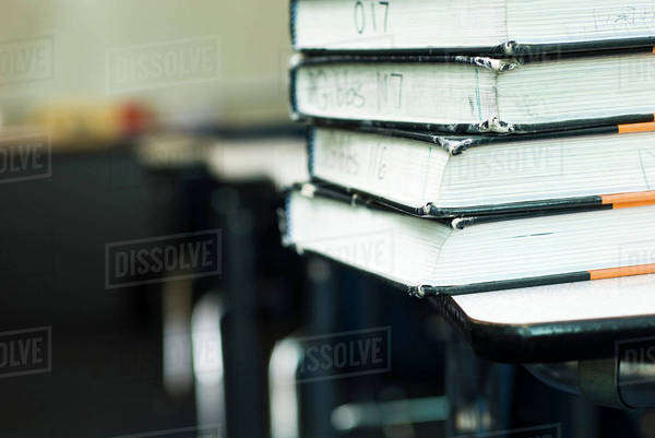 Stack of textbooks on school desk - Royalty-free Stock Photo | Dissolve