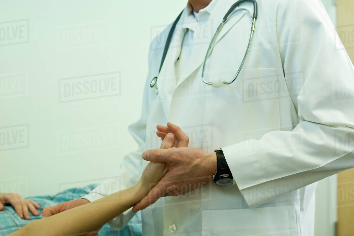 Doctor examining patient's arm - Royalty-free Stock Photo | Dissolve
