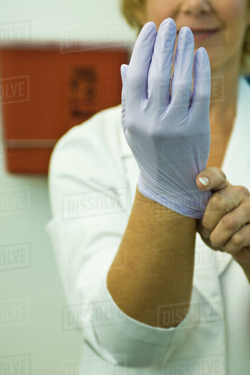 Putting on disposable latex glove - Royalty-free Stock Photo | Dissolve