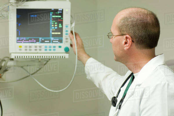 Doctor adjusting medical equipment monitor - Royalty-free Stock Photo ...