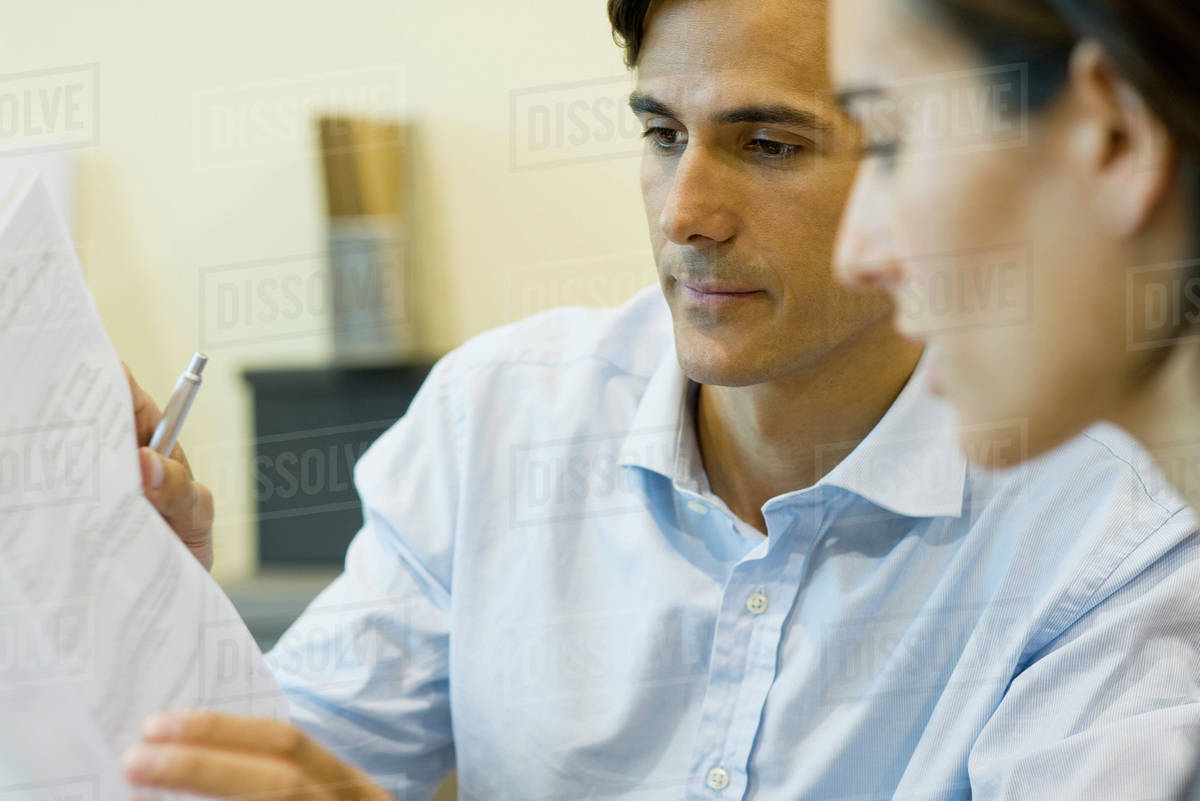 Businessman reviewing contract with client - Stock Photo - Dissolve