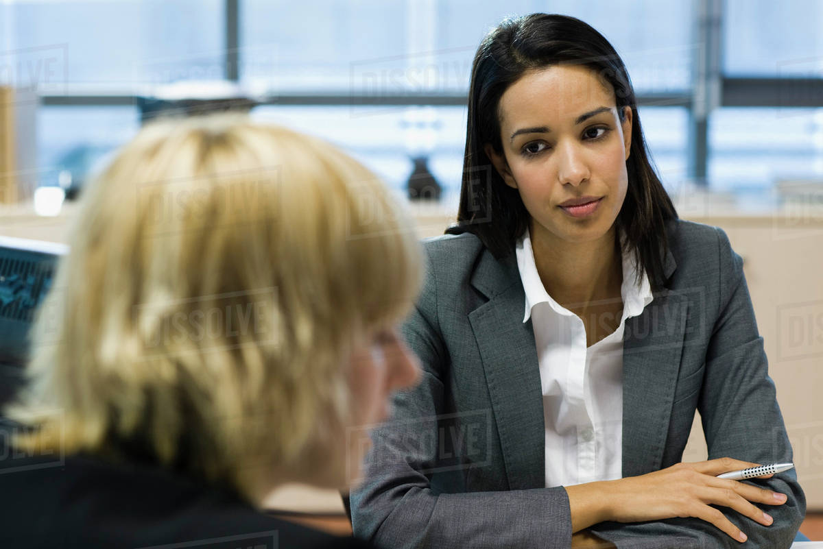 Female executive listening to colleague talk - Royalty-free Stock Photo ...