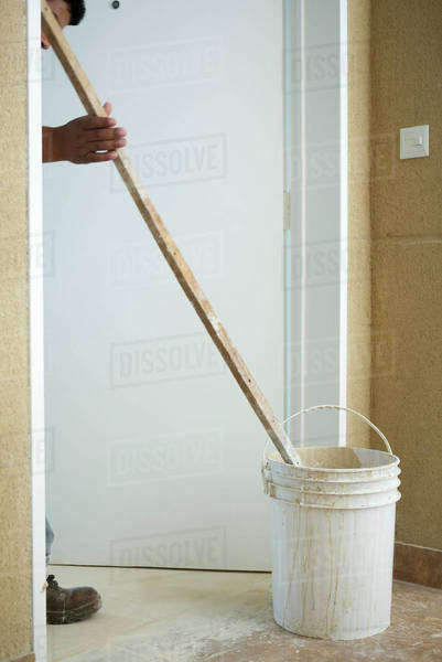 Worker mixing bucket of plaster - Royalty-free Stock Photo | Dissolve