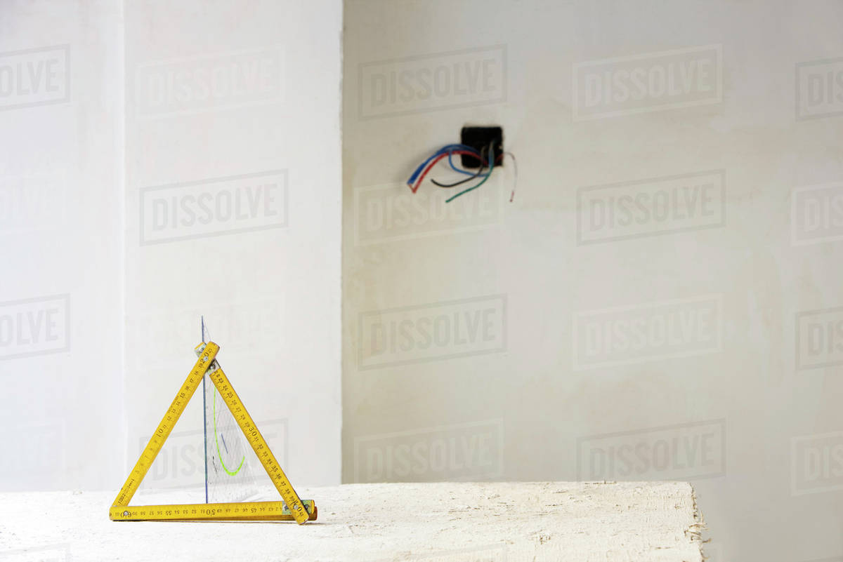 Set square, folding ruler on work table in unfinished room - Royalty ...