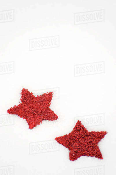 Red stars placed on snow - Stock Photo - Dissolve