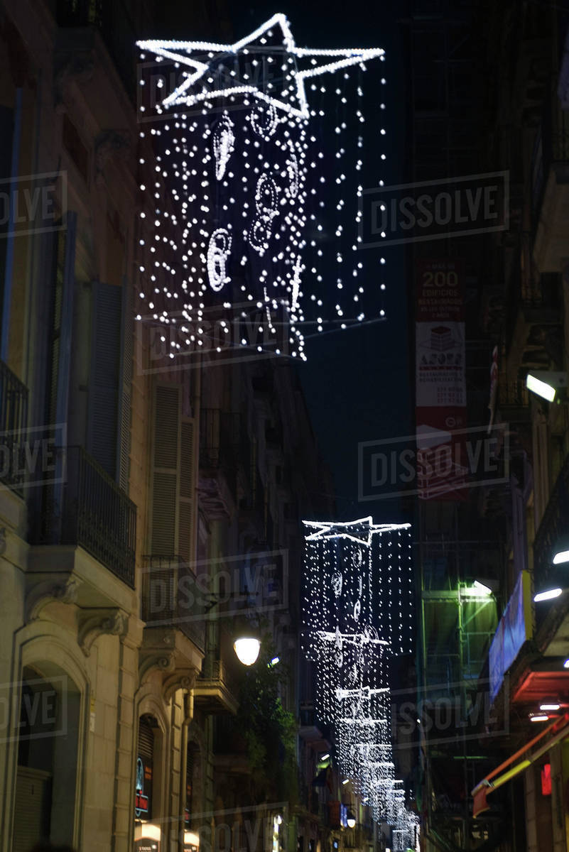 Star-shaped lights hanging along city street at night - Stock Photo ...