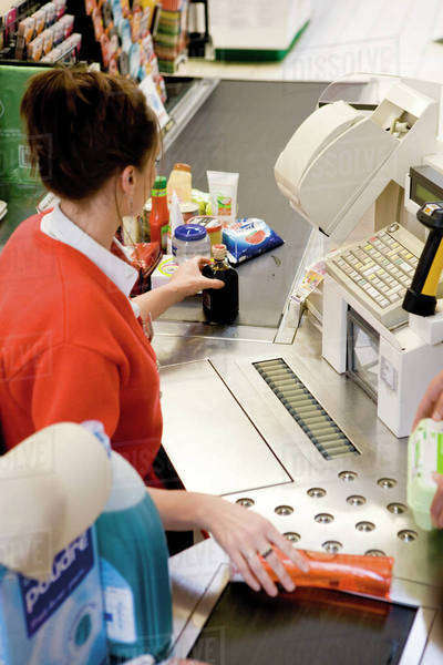 Cashier scanning purchases at checkout counter - Royalty-free Stock ...