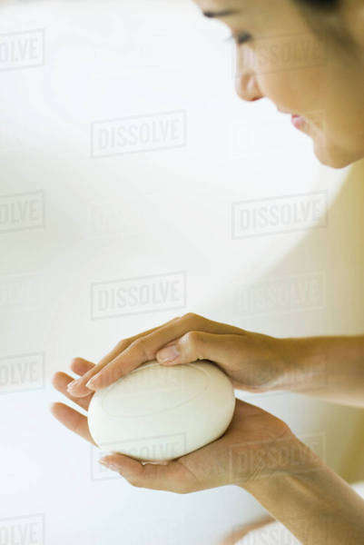 Woman holding bar of soap in hands, looking down, cropped view - Stock ...
