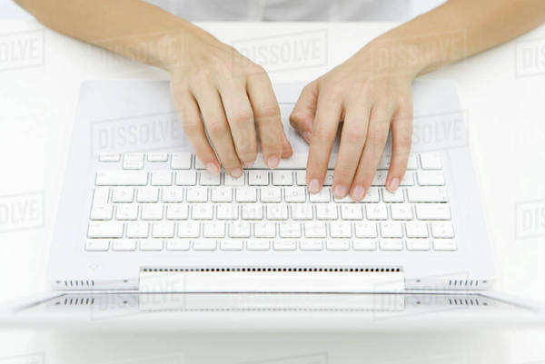 Person using laptop computer, cropped view of hands, overhead view ...