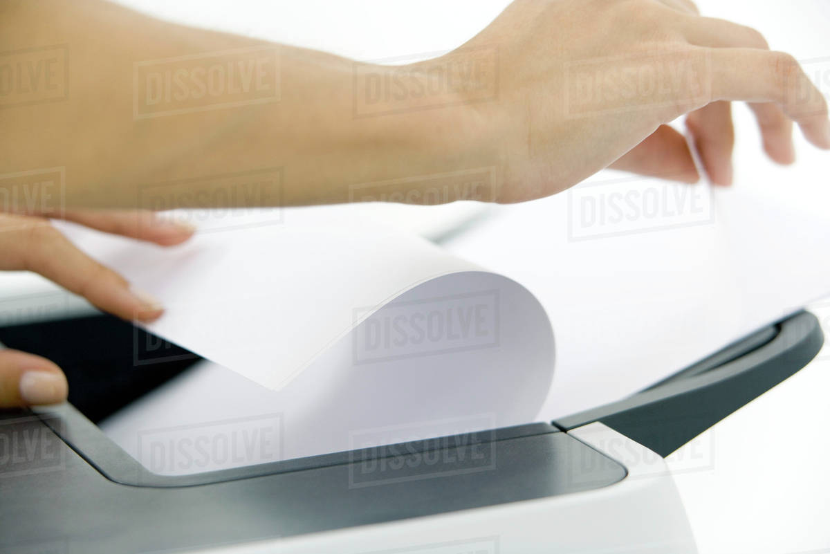 Hands arranging paper in printer, cropped - Stock Photo - Dissolve