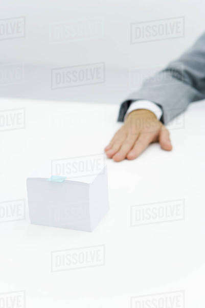 Stack of paper with small adhesive note stuck on it, cropped view of ...