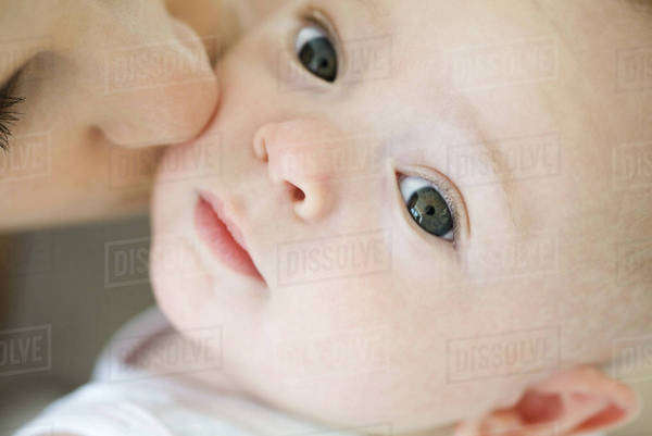 Infant looking at camera, mother kissing cheek, cropped - Royalty-free ...