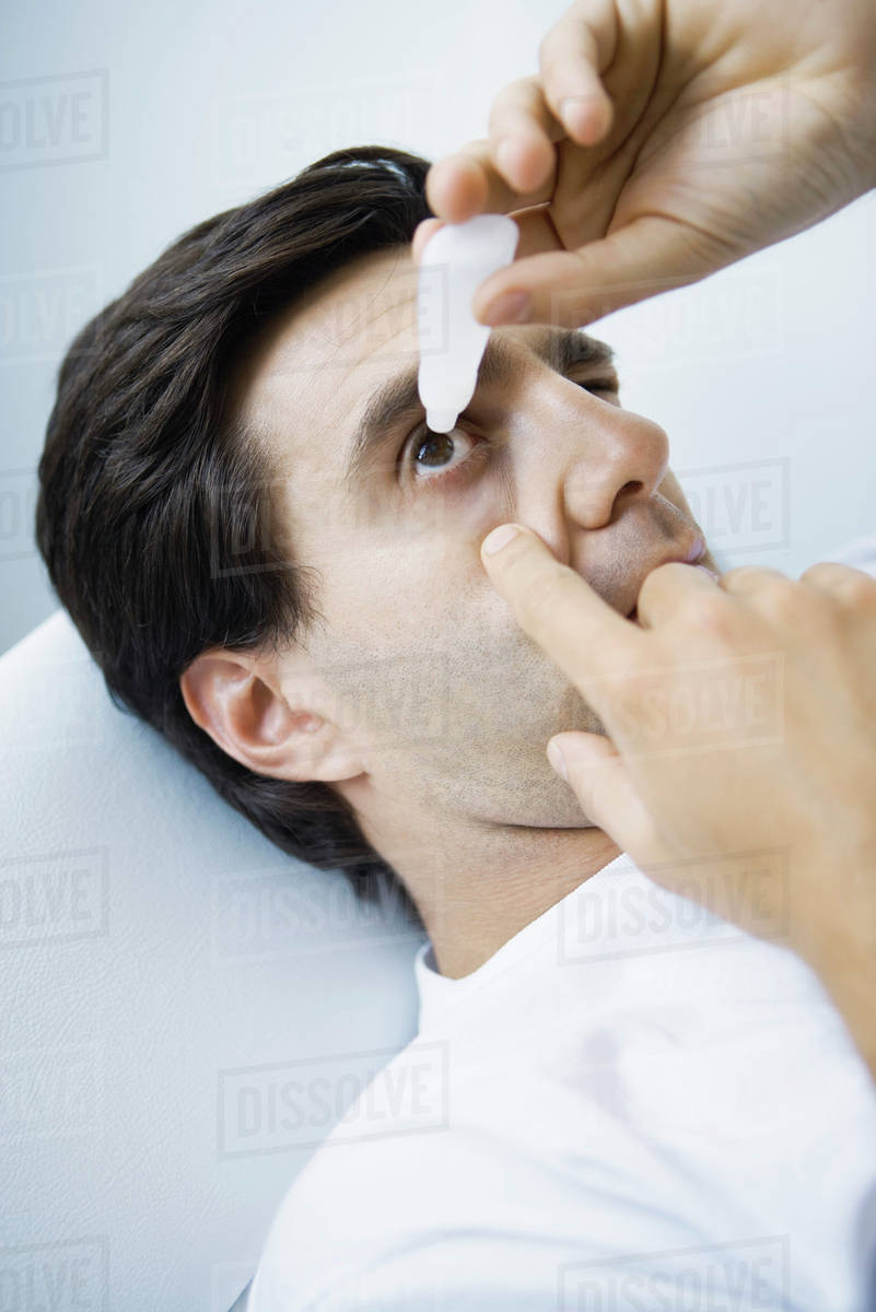 Man reclining, putting eyedrops in one eye - Royalty-free Stock Photo ...