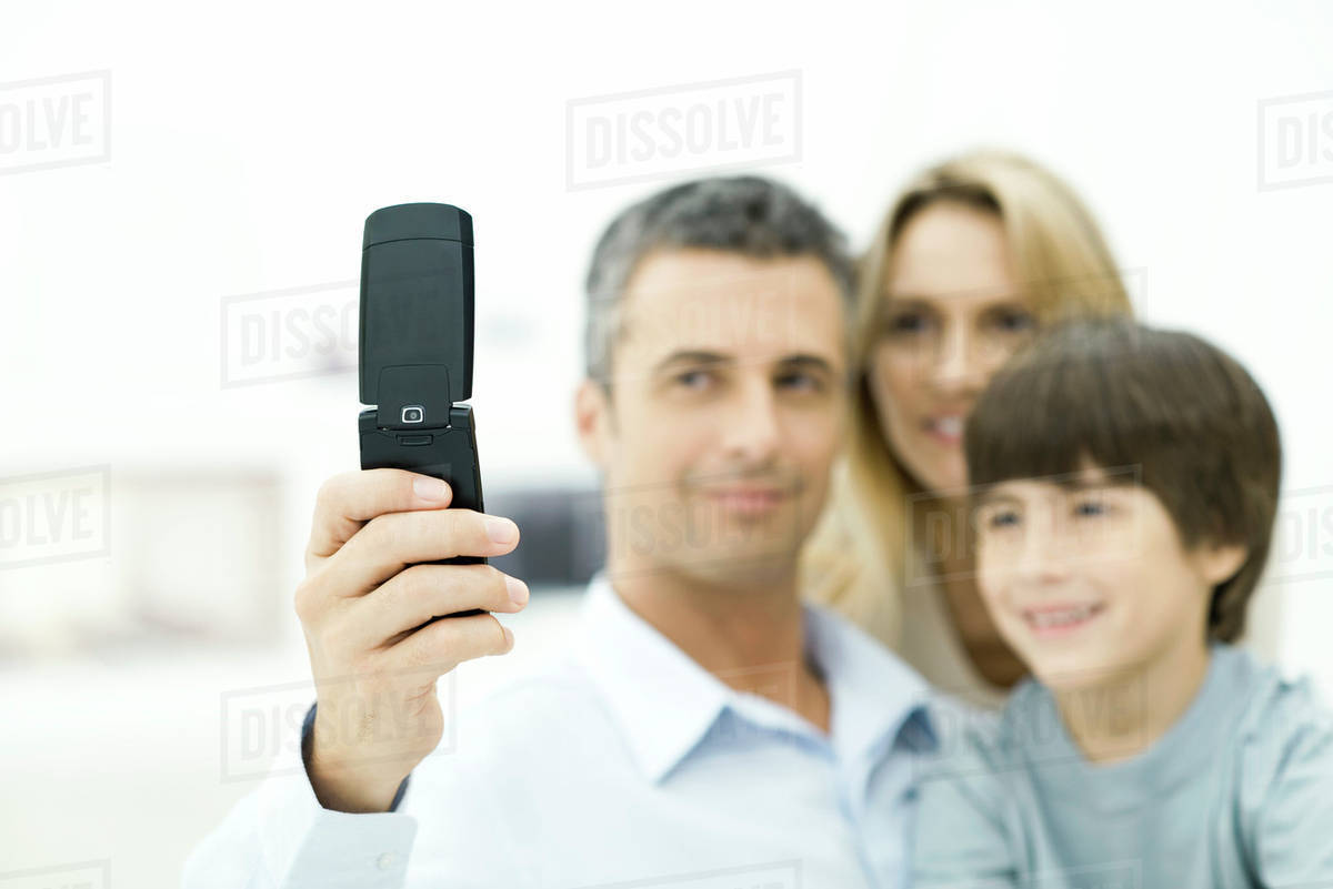 Family looking at cell phone together, focus on phone - Royalty-free ...