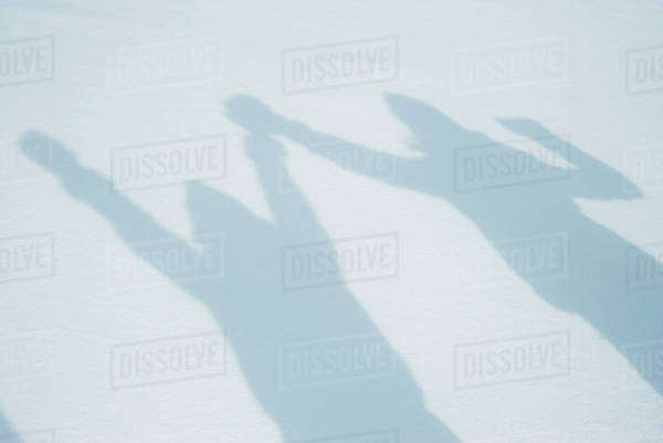 Shadow of people raising arms on snow - Royalty-free Stock Photo | Dissolve