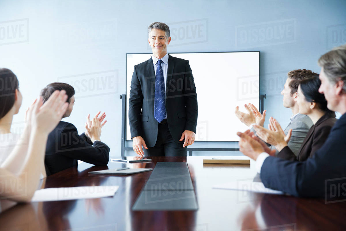 Business associates applauding colleague at meeting - Royalty-free ...