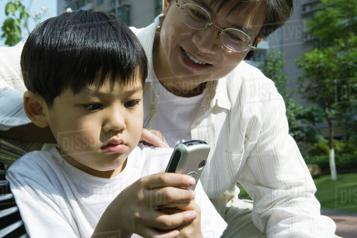 Father and son, boy looking at cell phone - Royalty-free Stock Photo ...