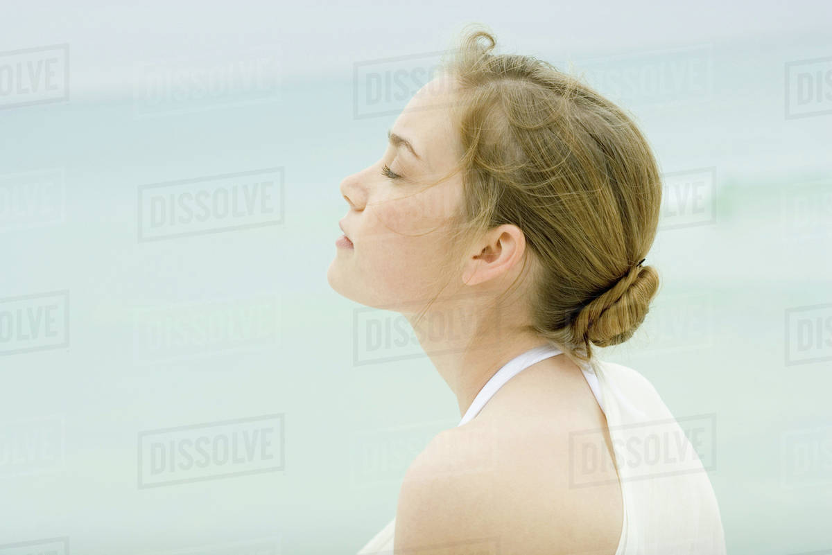 Young woman, head and shoulders, side view, sea in background - Stock ...