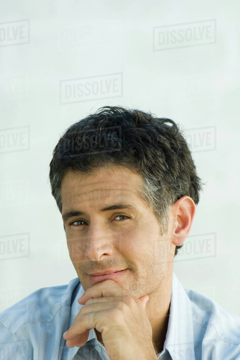 Man holding chin and looking at camera, head and shoulders, portrait ...