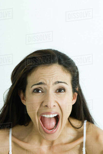 Woman screaming, looking at camera, head and shoulders, portrait ...