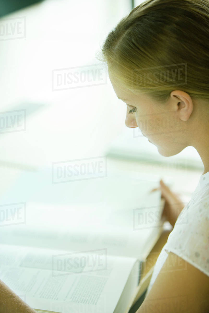Female college student sitting at table in library, studying - Royalty ...