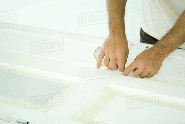 Man taping door with adhesive tape, cropped view of hands - Stock Photo ...