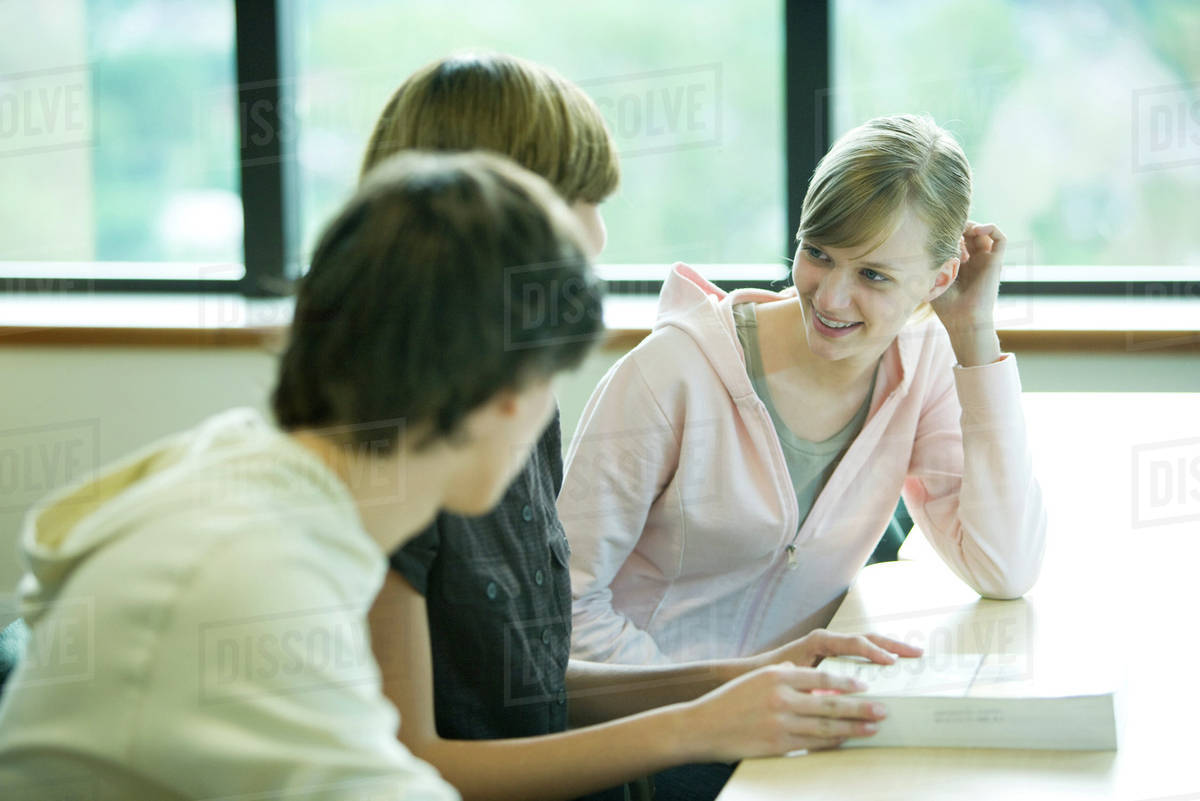 Three students sitting at table, chatting - Royalty-free Stock Photo ...