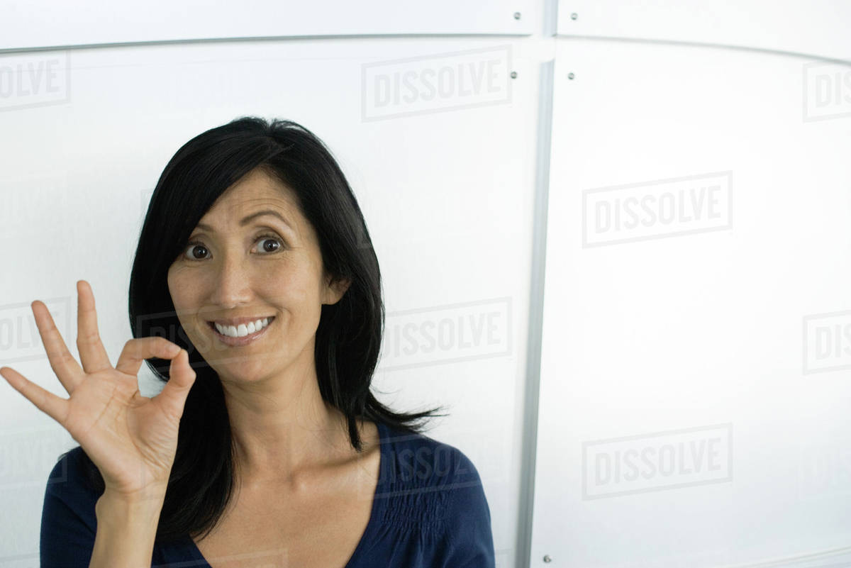 Woman making OK hand gesture, smiling at camera - Royalty-free Stock ...