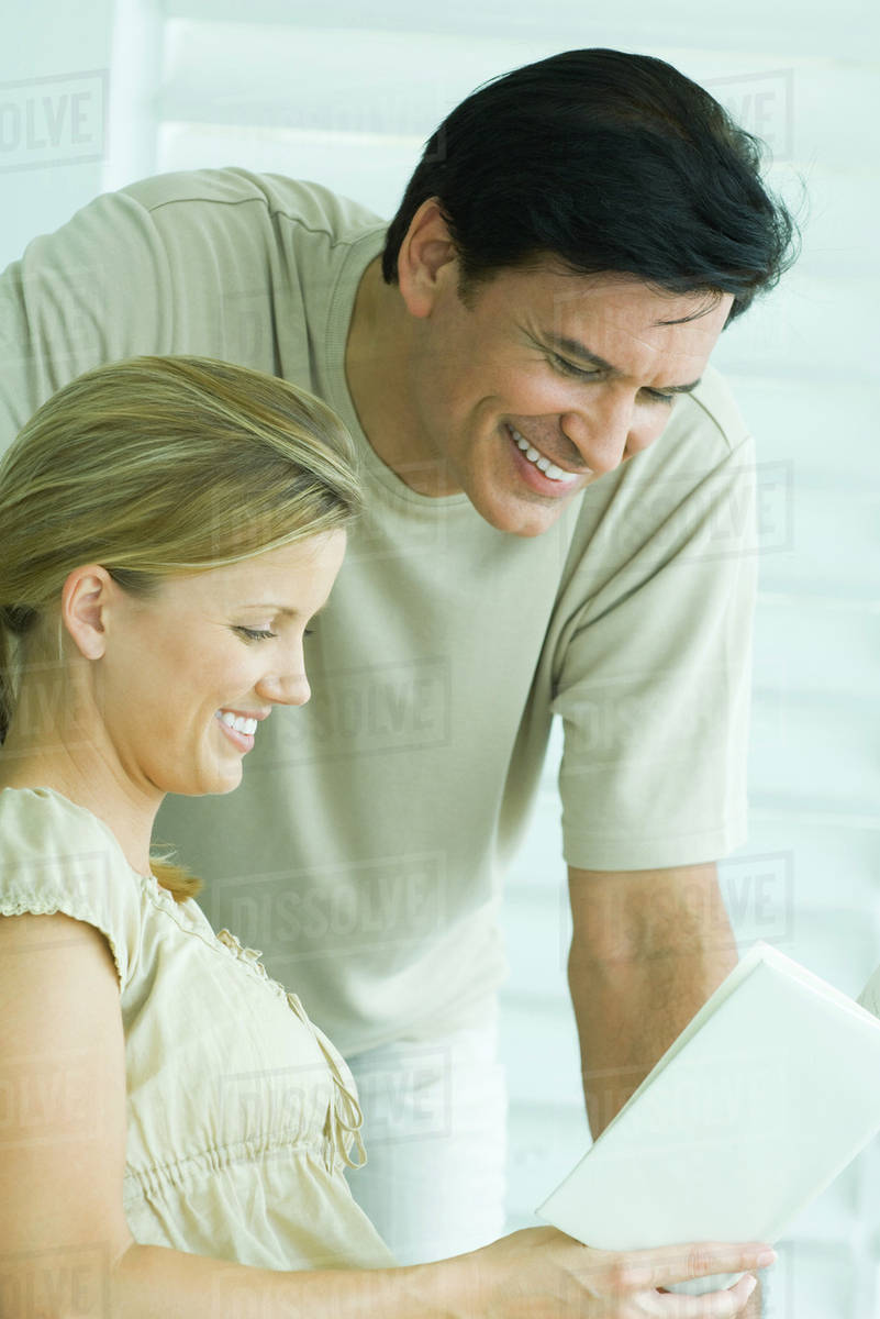 Couple reading book together, both smiling, close-up - Royalty-free ...