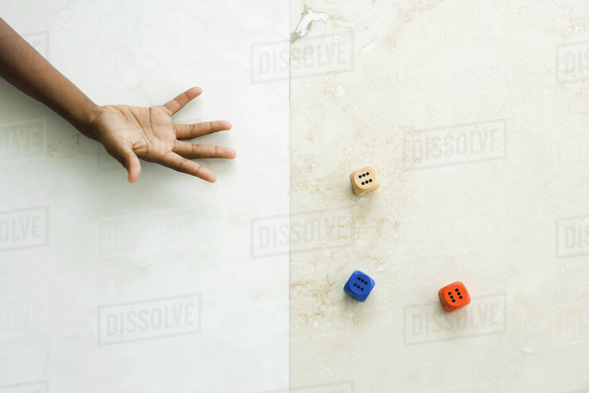 Child throwing dice, cropped view of hand - Stock Photo - Dissolve