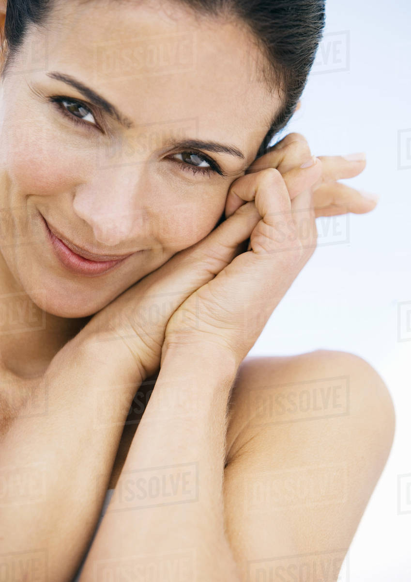 Woman smiling and leaning head against clasped hands - Royalty-free ...