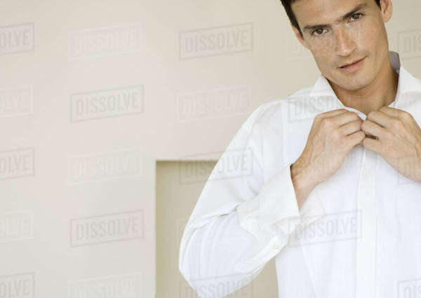 Man buttoning shirt - Stock Photo - Dissolve