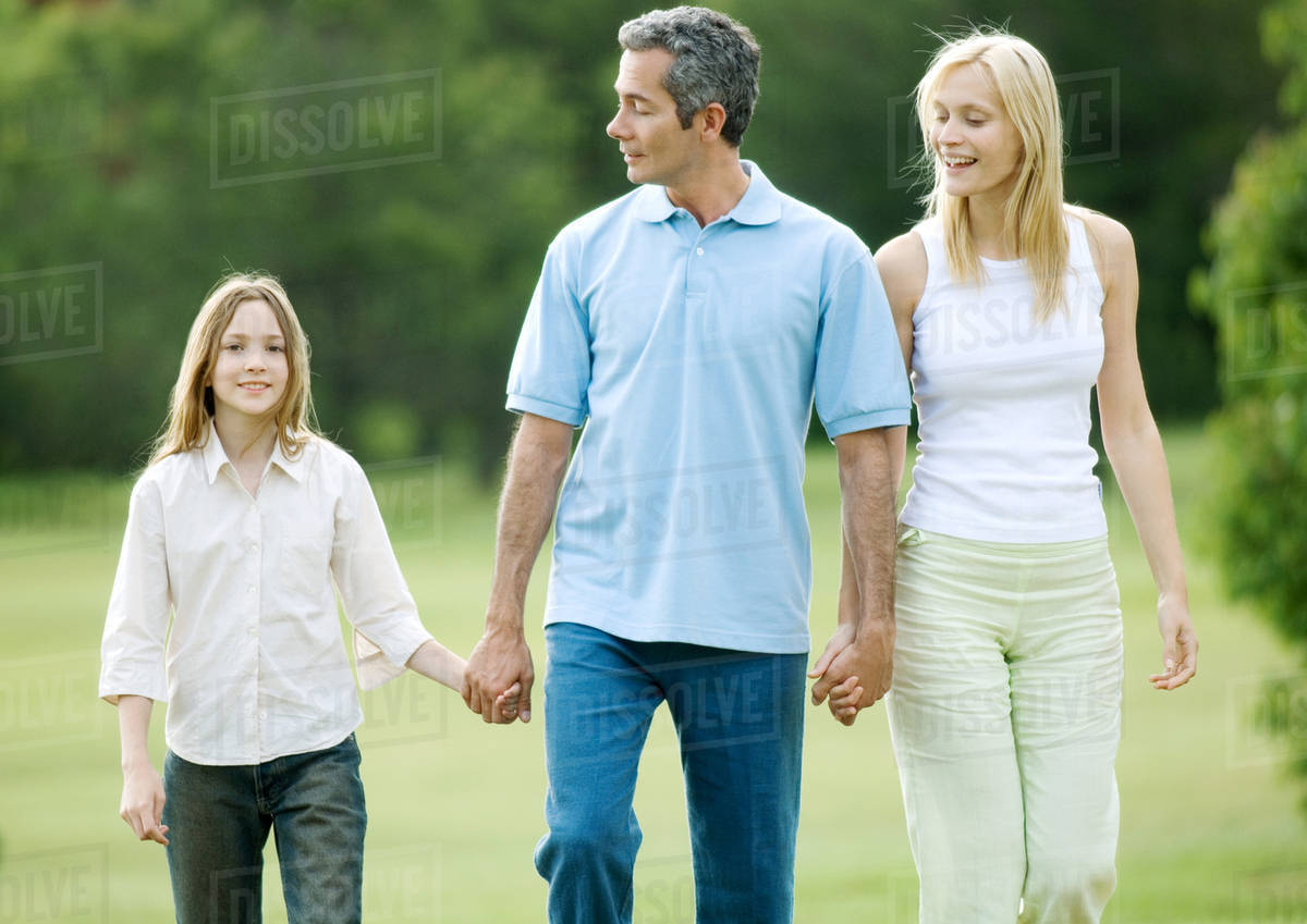 Girl taking walk with parents - Royalty-free Stock Photo | Dissolve