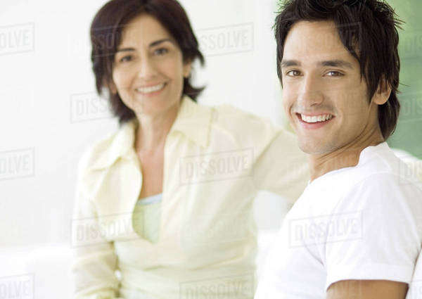 Young man with mother in background - Stock Photo - Dissolve