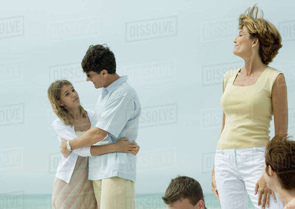Man hugging teenage daughter while mother watches - Royalty-free Stock ...