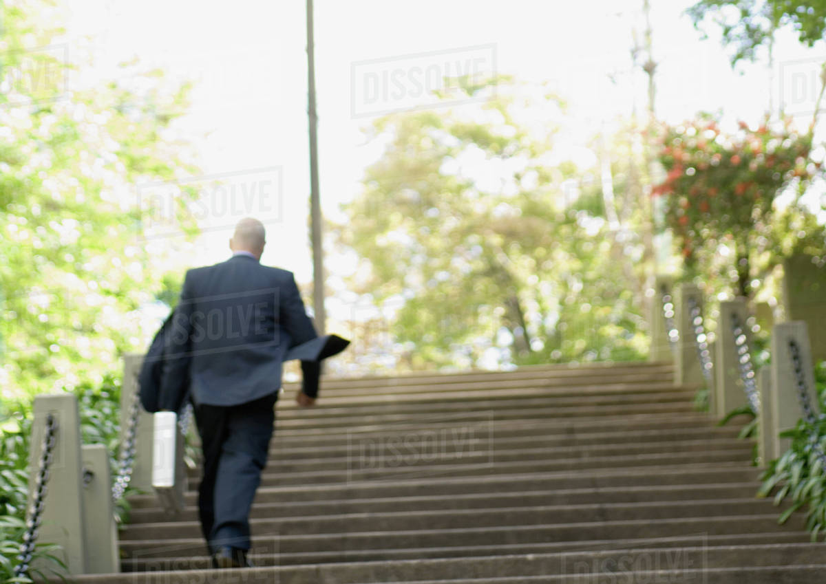 Businessman walking up stairs, rear view - Royalty-free Stock Photo ...