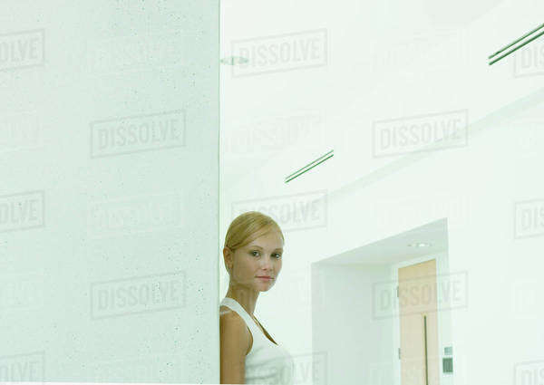 Woman standing in hallway of office building - Stock Photo - Dissolve