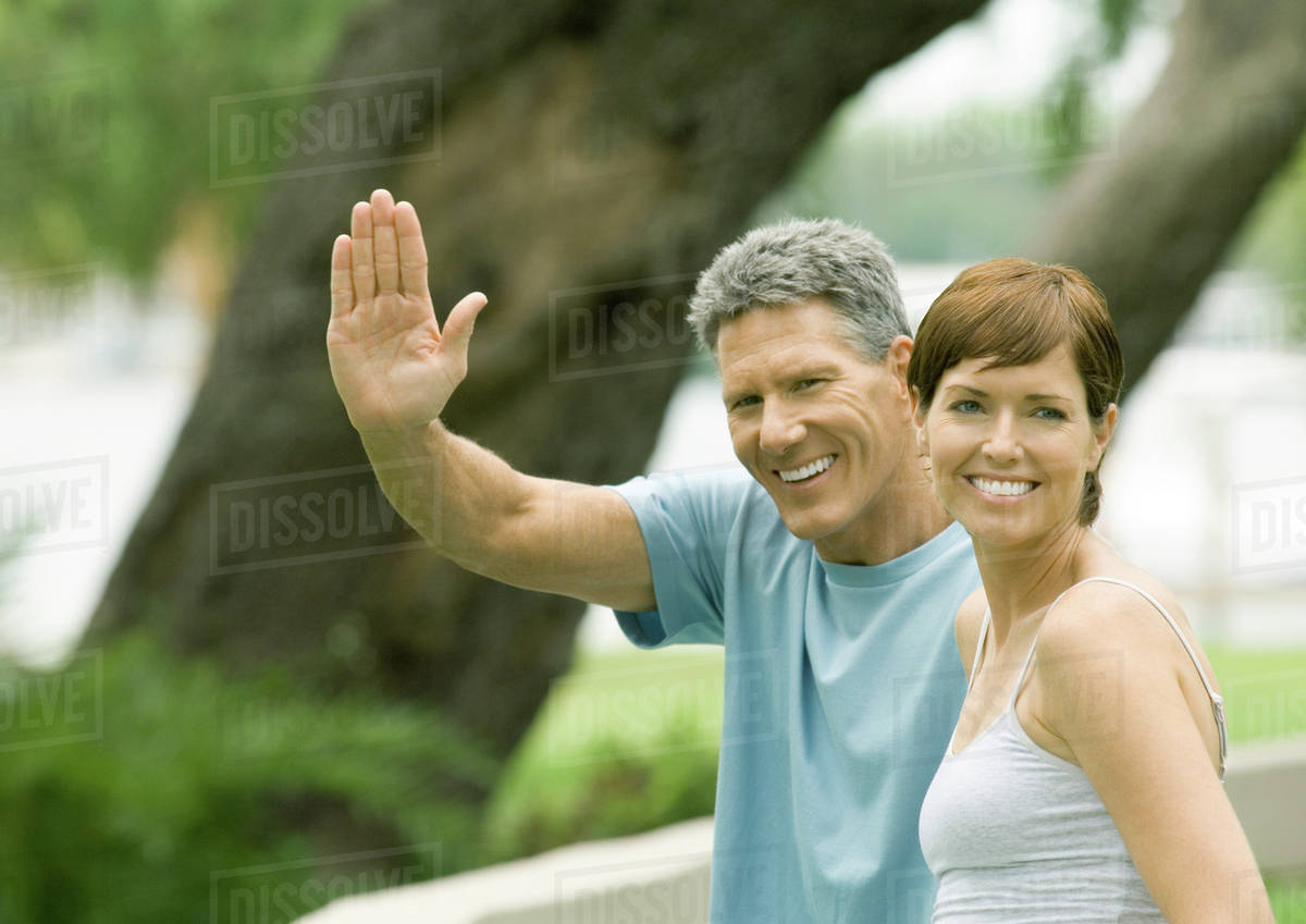 Mature couple, man waving - Royalty-free Stock Photo | Dissolve