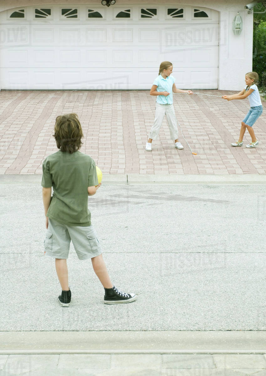 Suburban children playing in driveway - Royalty-free Stock Photo | Dissolve