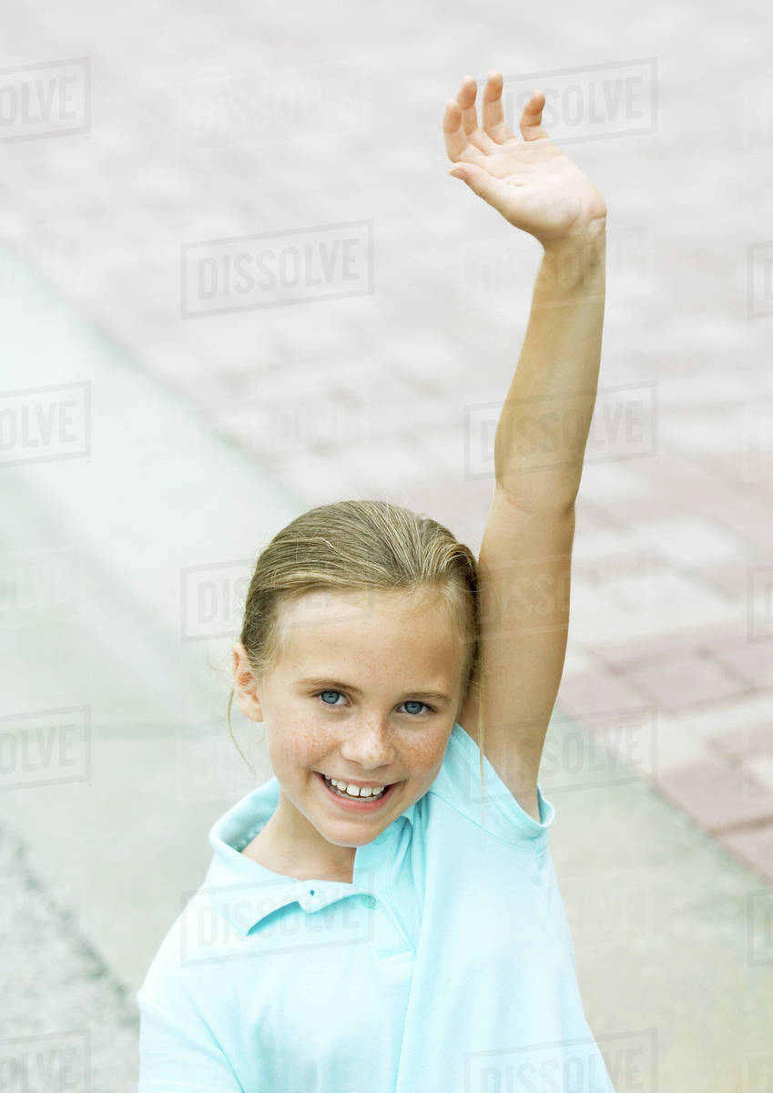 Girl raising hand, smiling - Stock Photo - Dissolve