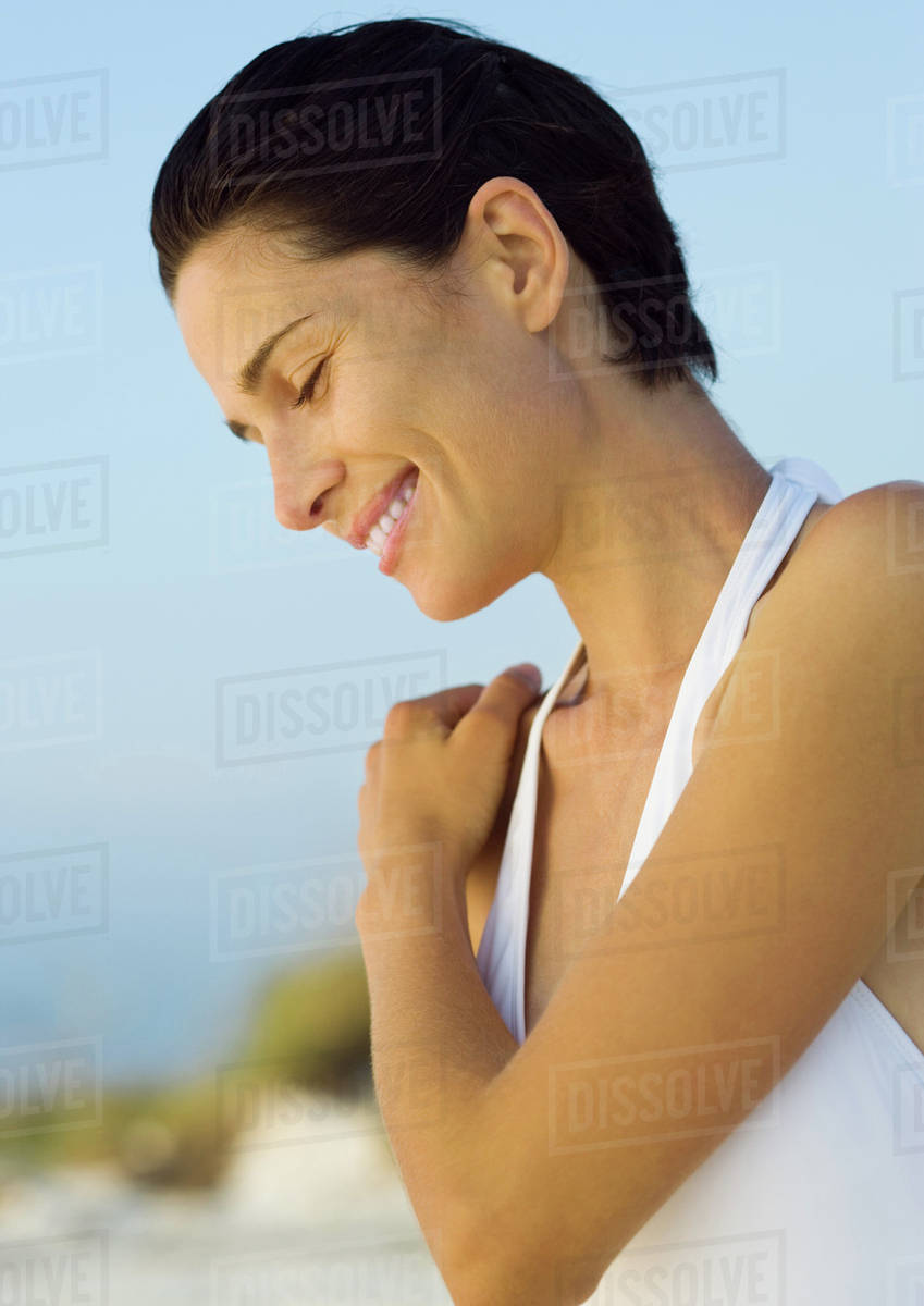 Woman smiling, looking down - Stock Photo - Dissolve