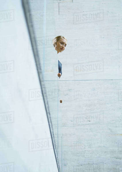 Woman looking over edge of balcony - Royalty-free Stock Photo | Dissolve