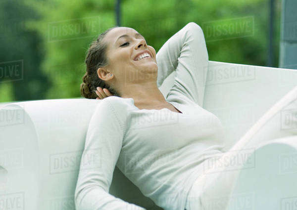 Woman lounging in armchair - Royalty-free Stock Photo | Dissolve