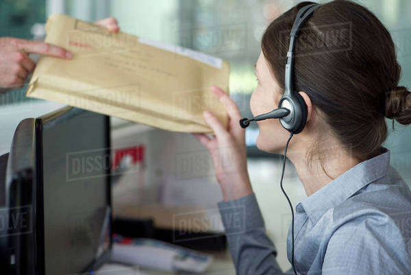 Receptionist receiving mail from delivery person - Royalty-free Stock ...