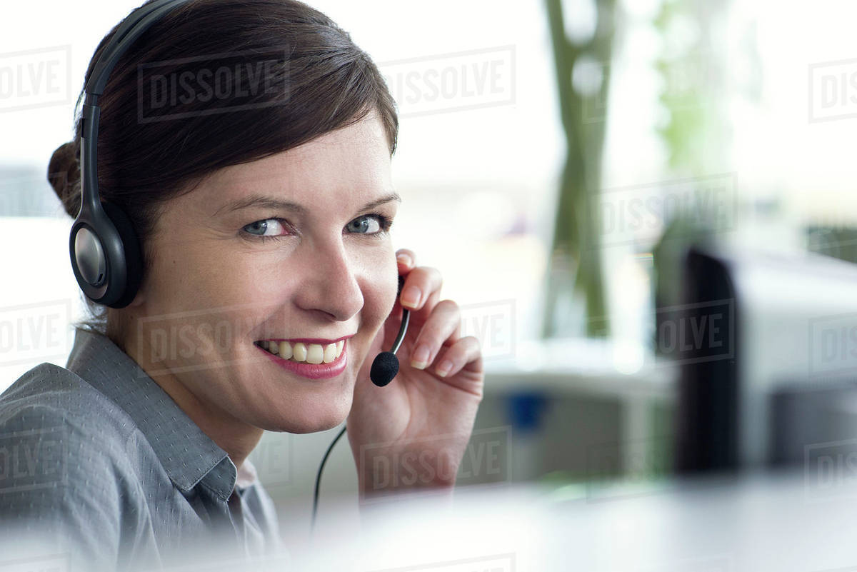 Receptionist smiling cheerfully - Stock Photo - Dissolve