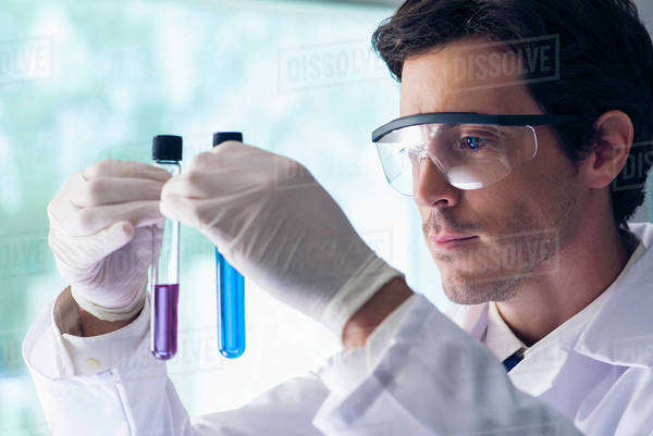 Scientist scrutinizing test tubes in lab - Royalty-free Stock Photo ...