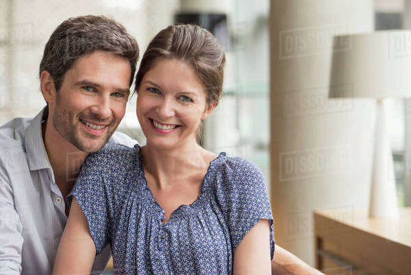 Couple smiling together at home, portrait - Stock Photo - Dissolve