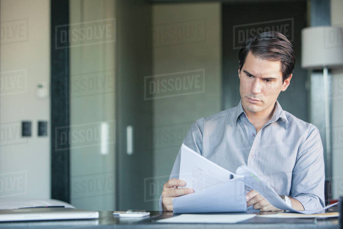 Man reading document in office - Royalty-free Stock Photo | Dissolve